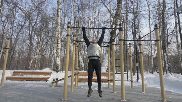Young Man Doing Pull Up Exercise on Crossbar During Winter Gym Workout ...