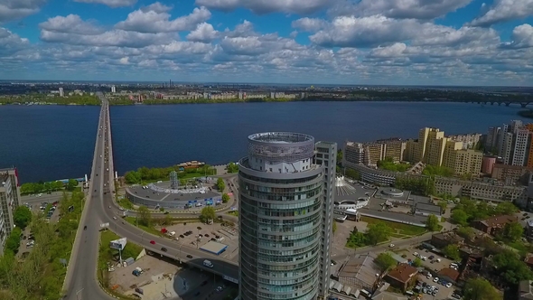 Aerial Survey of a Skyscraper Near a River with a Bridge, Stock Footage