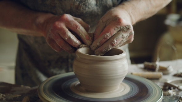 Professional Potter Is Making Clayware on Potter's Wheel, Looking at ...