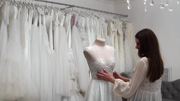 Beautiful Girl Looking at Wedding Dress in the Shop Compared to Other ...