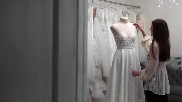 Beautiful Girl Looking at Wedding Dress in the Shop Compared to Other ...