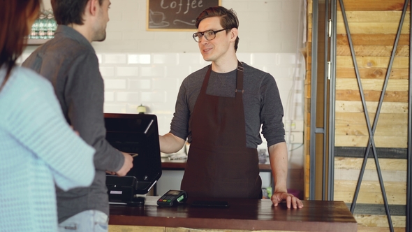 Cheerful Friendly Cashier Is Taking Orders From Customers Standing in ...