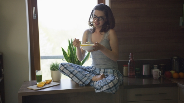 Young Woman Sitting on Table and Eating Breakfast, Stock Footage ...