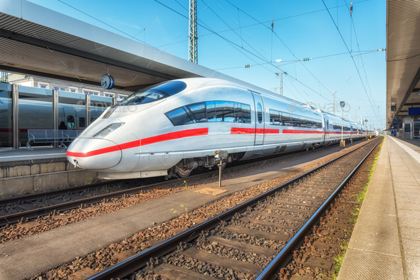 High speed white train on the railway station Stock Photo by den-belitsky