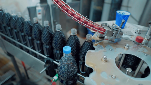The Production Line of Carbonated Beverages. Water and Soda in Bottles ...