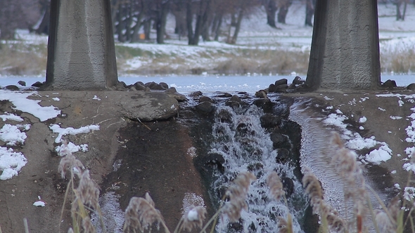Little Waterfall under the Bridge on the Background of Lake at Winter ...