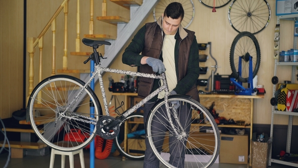 Young Maintenance Man Is Assembling Bicycle Placing Stearing Wheel and ...