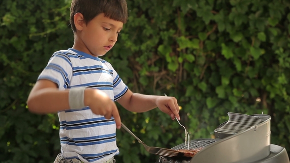 Boy Cooking Steak on the Grill., Stock Footage | VideoHive