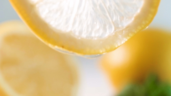 Footage of Drop Slowly Dripping From Side of Lemon Slice, Stock Footage
