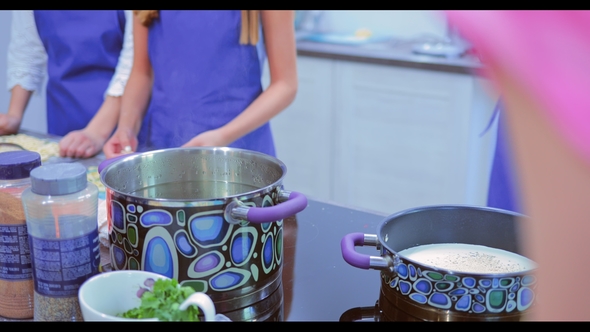 Boiling Water in a Pan A Woman in the Kitchen with the Kids, Cooking ...
