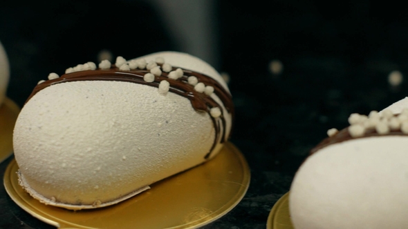 White Pastries Lying in a Row and Being Decorated with Chocolate, Stock ...