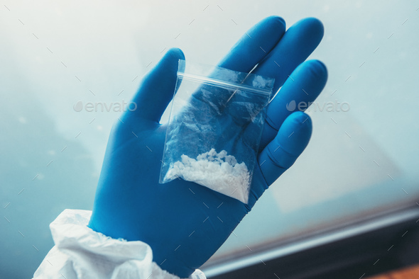Criminology expert collecting drug evidence at crime scene Stock Photo ...