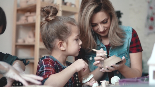 A Little Girl Is Making a Clay Craft in a Pottery Workshop. Mom and ...