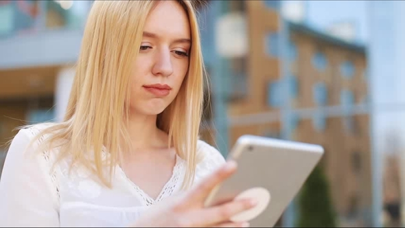 Pretty Young Blonde Woman Using Tablet Computer Device Outside on the ...