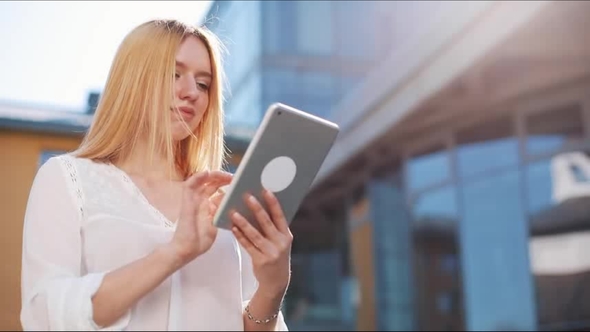 Pretty Young Blonde Woman Using Tablet Computer Device Outside on the ...