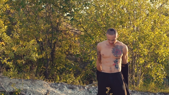 The Brutal Man Tearing T-shirt on Himself on the Rock. Slowly, Stock ...