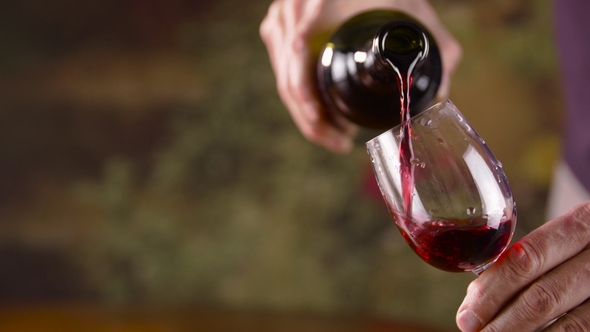 Male Hand Pouring Red Wine in Glass From Bottle . Man Pouring Red Wine ...