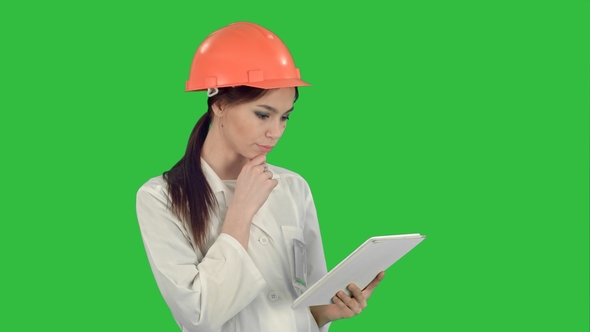 Female Engineer in Helmet Using Tablet Computer on a Green Screen ...