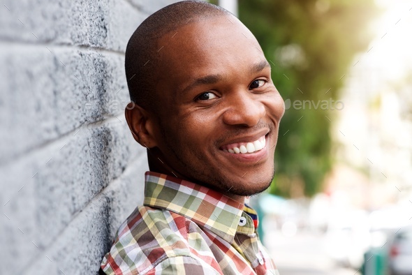 handsome young african man smiling Stock Photo by mimagephotography