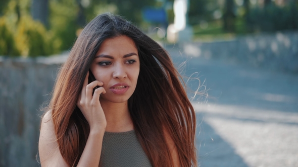Indignant and Dissatisfied Girl Speaks on the Phone, Stock Footage