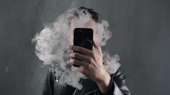 Smoker Man in Leather Jacket Hide His Face with Smartphone and Blowing ...