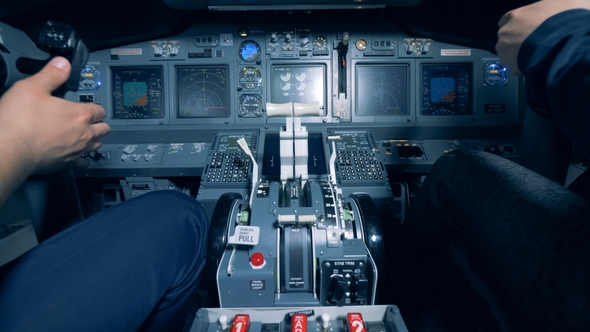 Two Men Are Sitting in a Cockpit of a Flight Simulator and Are ...