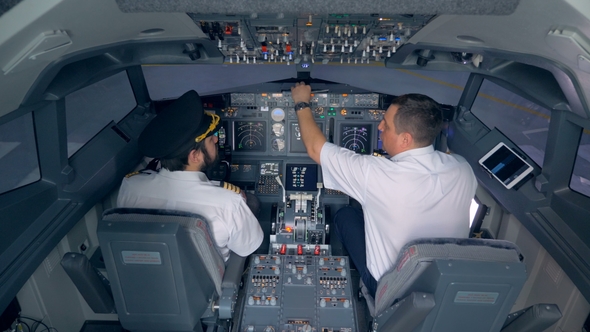 Two Pilots Are Sitting in an Airplane Cabin and Discussing Something ...