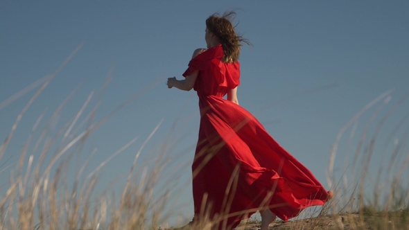 Young Female Model in Scarlet Flowing in the Wind Dress and Barefoot ...