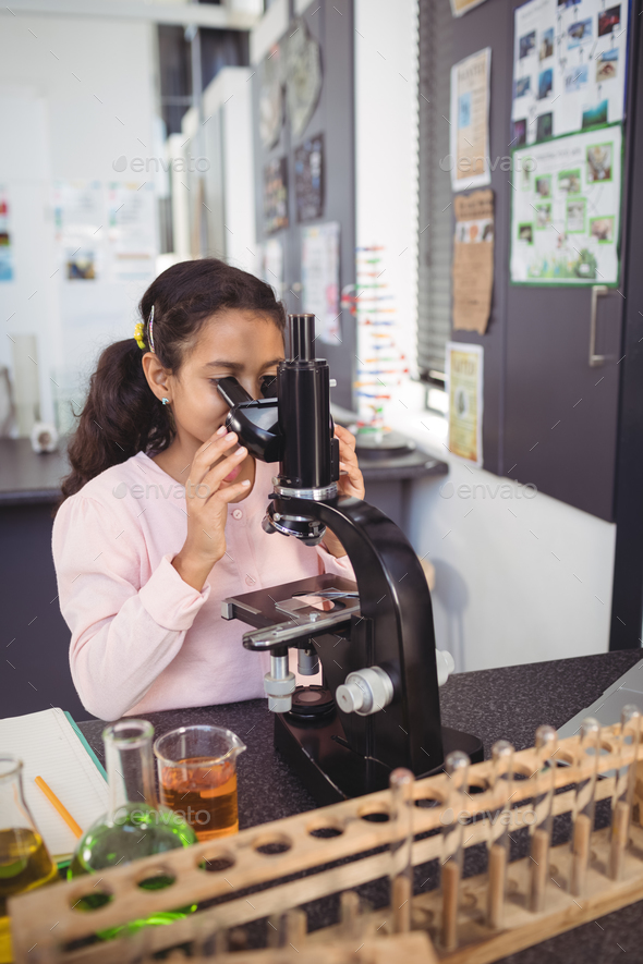 Elementary student looking through microscope at laboratory Stock Photo ...