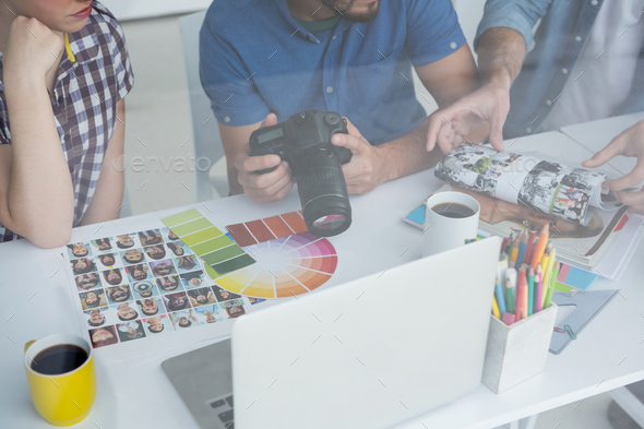 Team of photographers working together at desk Stock Photo by ...