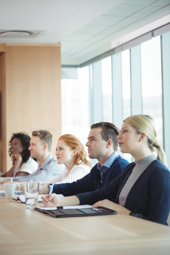 Business people sitting at conference table during meeting Stock Photo ...