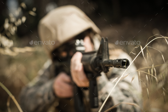 Military soldier hiding in grass while guarding with a rifle Stock ...