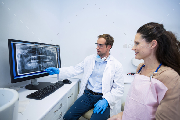Dentist showing an x-ray of teeth to female patient Stock Photo by ...