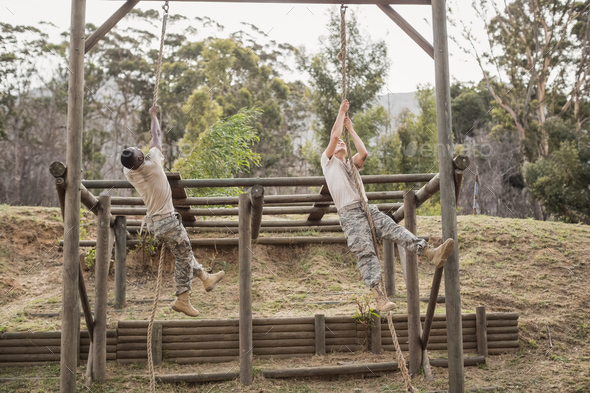 Military soldiers climbing rope during obstacle course training Stock ...