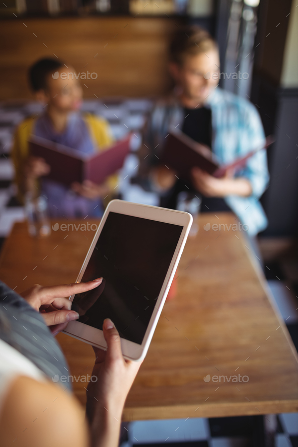 Waitress using digital tablet while taking order Stock Photo by ...