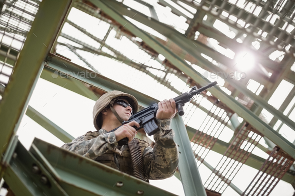Military soldier guarding with a rifle Stock Photo by Wavebreakmedia