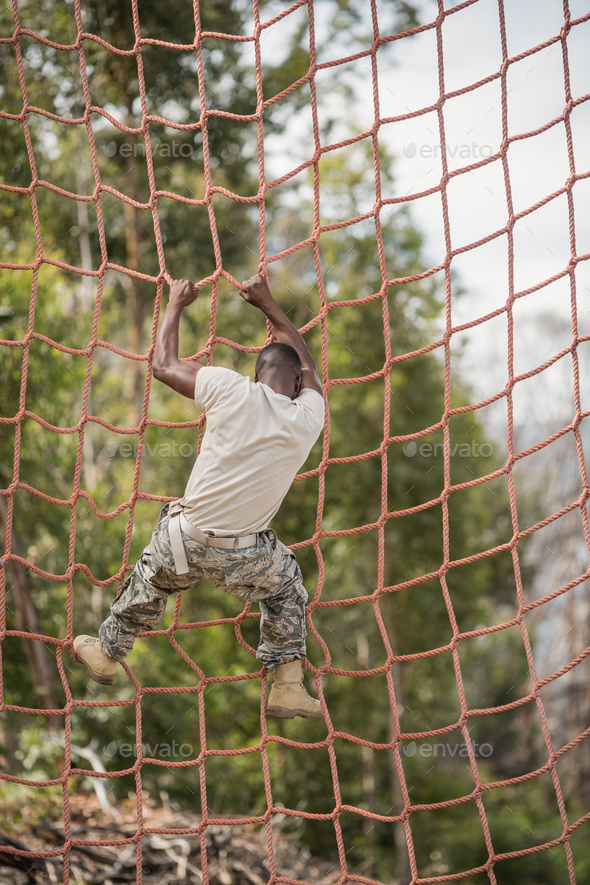 Military soldier climbing net during obstacle course Stock Photo by ...