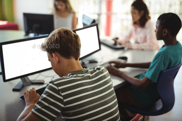 Students using computer in classroom Stock Photo by Wavebreakmedia