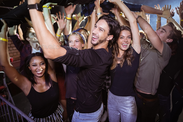 Cheerful crowd lifting performer at nightclub Stock Photo by Wavebreakmedia