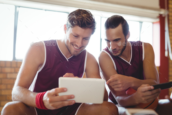 Basketball players talking while using digital tablet Stock Photo by ...