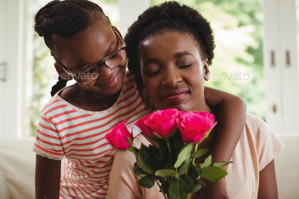 Daughter with arms around mother shoulders Stock Photo by Wavebreakmedia