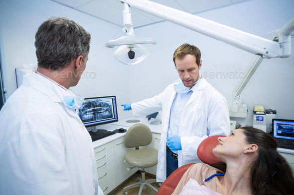 Dentists showing an x-ray of teeth to female patient Stock Photo by ...