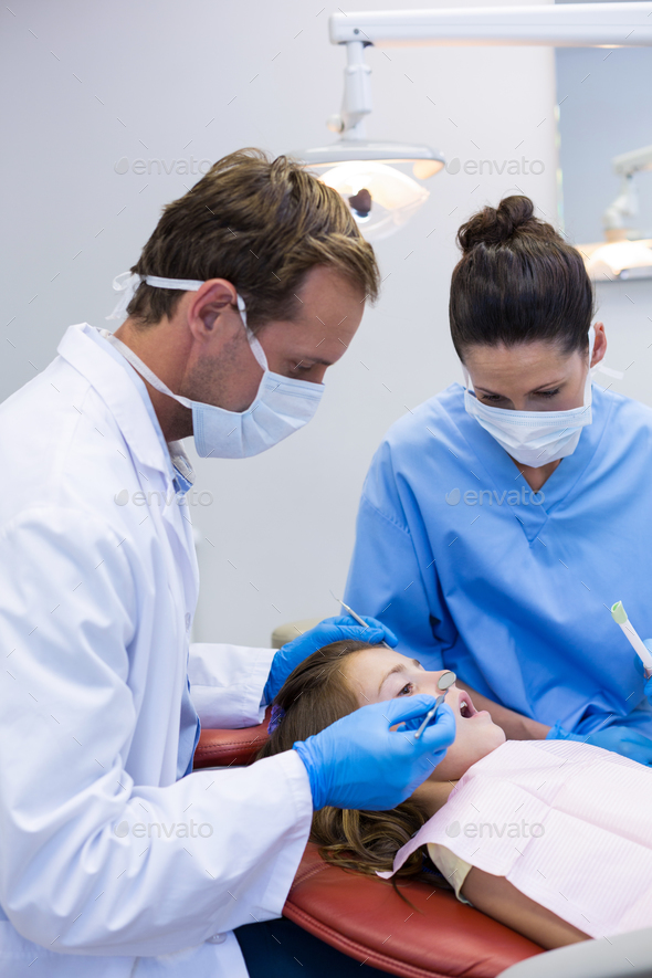 Dentist examining a young patient with tools Stock Photo by Wavebreakmedia