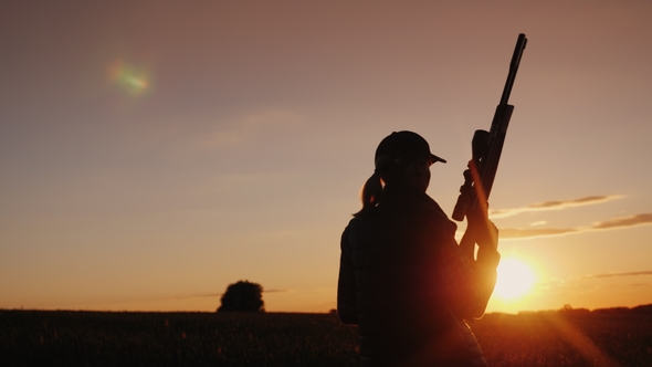 A Woman with a Gun Goes Across the Field. The Beginning of the Hunting ...