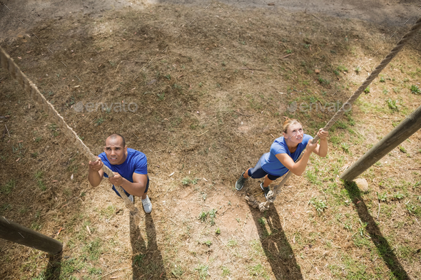 Fit person climbing down the rope during obstacle course Stock Photo by ...