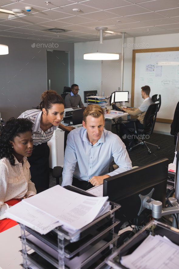 Business colleagues looking at desktop monitor in office Stock Photo by ...