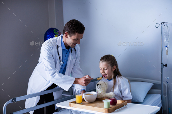 Doctor feeding breakfast to patient Stock Photo by Wavebreakmedia ...