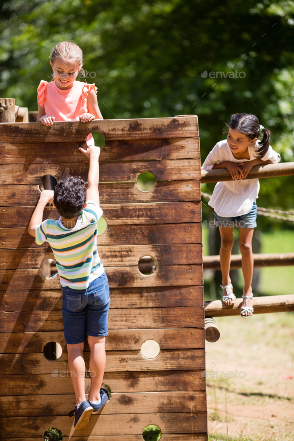 Kids playing on a playground ride in park Stock Photo by Wavebreakmedia