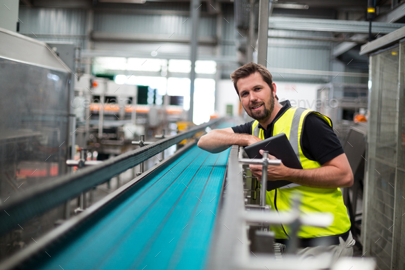Portrait of smiling factory worker standing with a digital tablet Stock ...