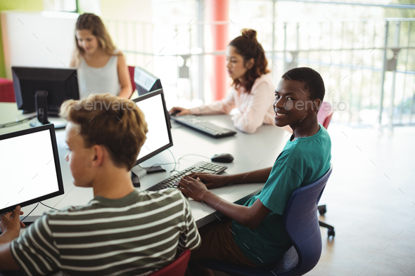 Students using computer in classroom Stock Photo by Wavebreakmedia